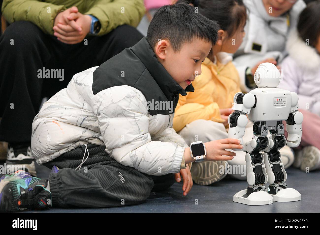 NANJING, CHINA - FEBRUARY 22, 2025 - A child looks at a robot at the ...