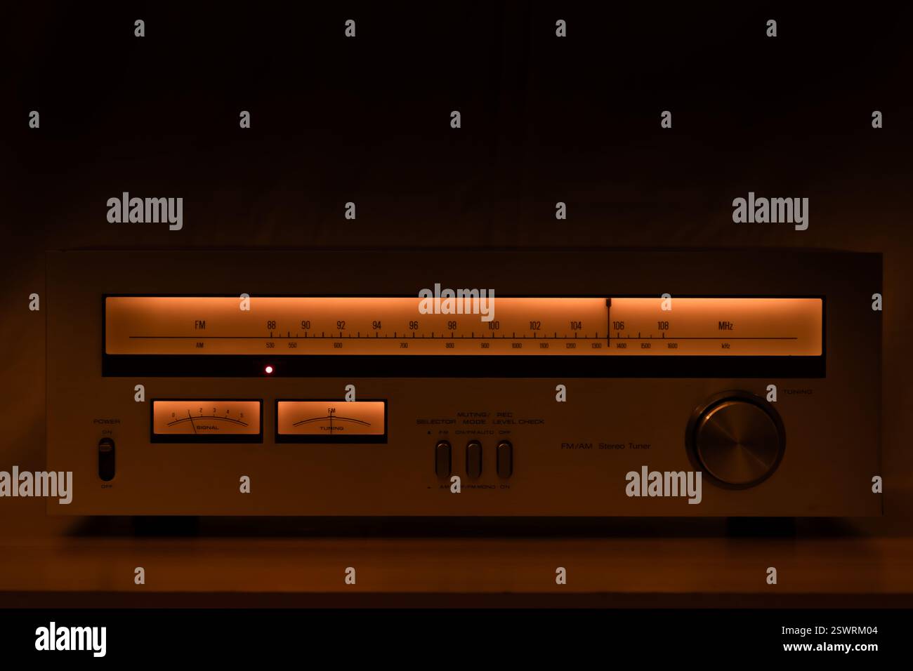 A vintage analog radio receiver with a glowing illuminated AM/FM tuning ...