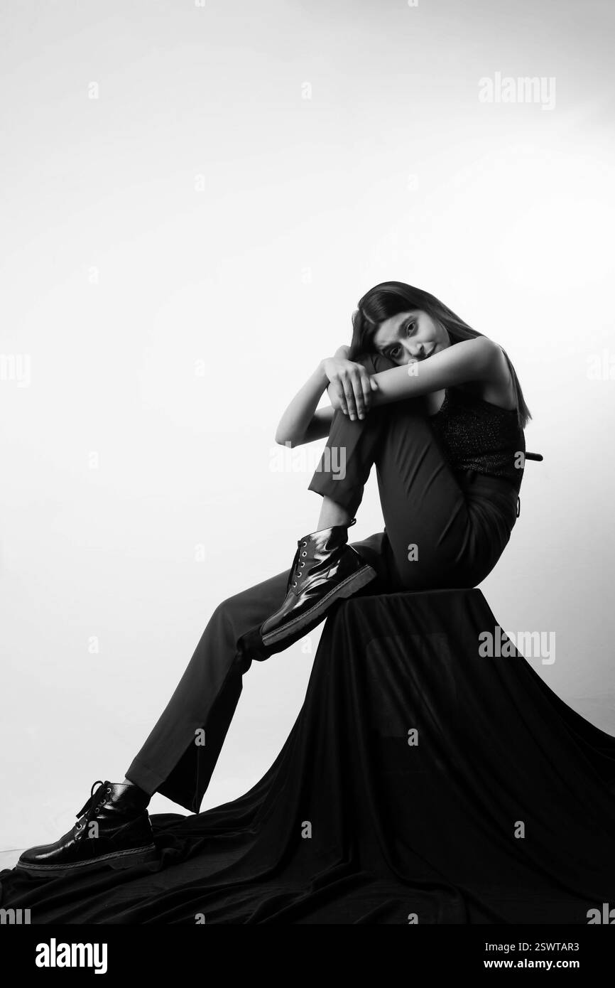 a tall slim caucasian female model with black hair wearing a black suit ...