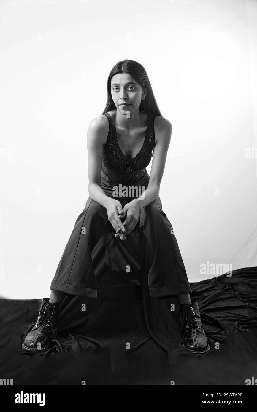 a tall slim caucasian female model with black hair wearing a black suit ...