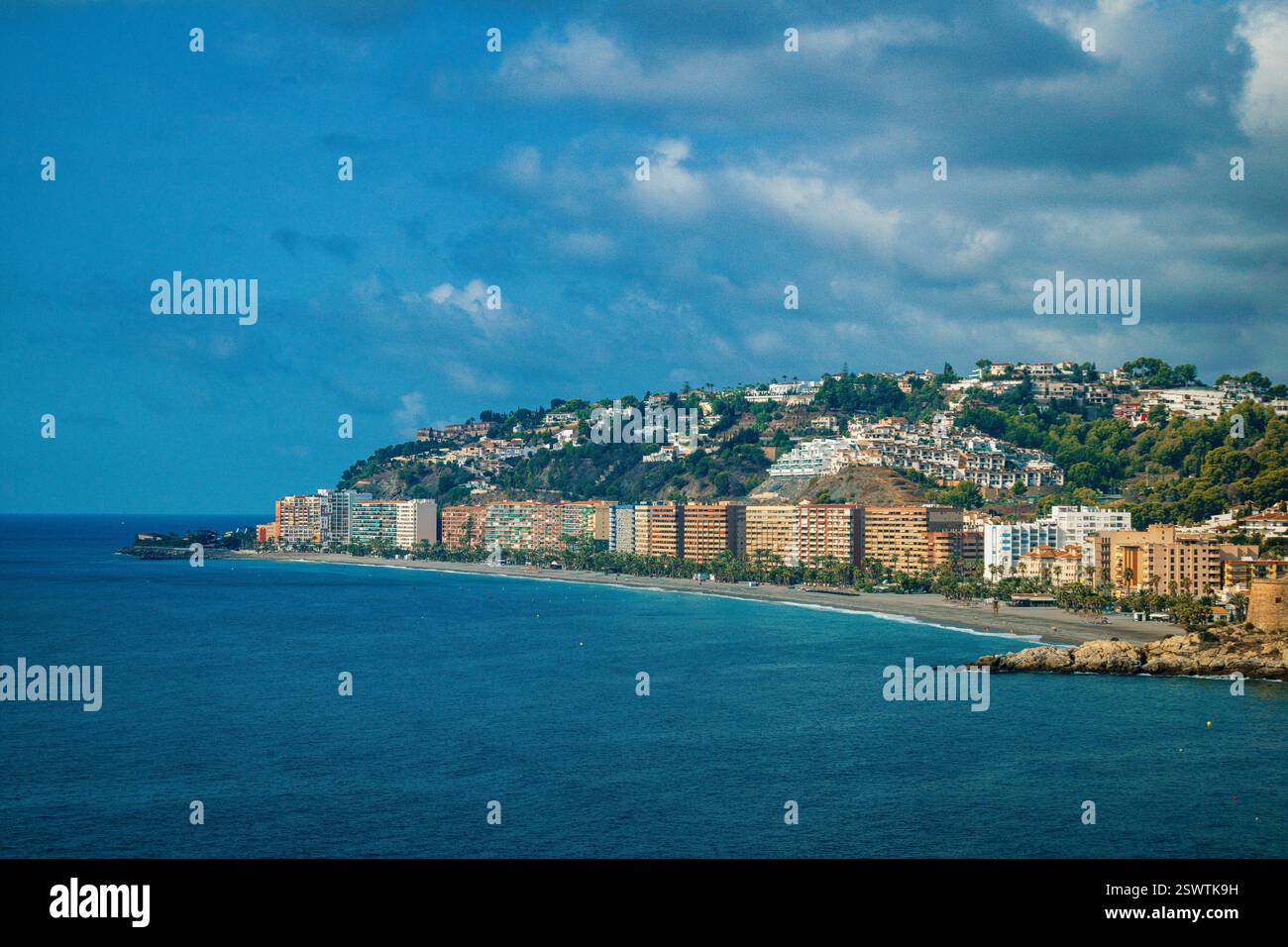 High angled view of Almunecar Town across a beautiful bay beneath blue ...