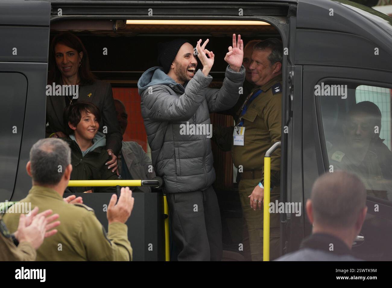 Freed Israeli hostage Tal Shoham waves from a van as he arrives at ...