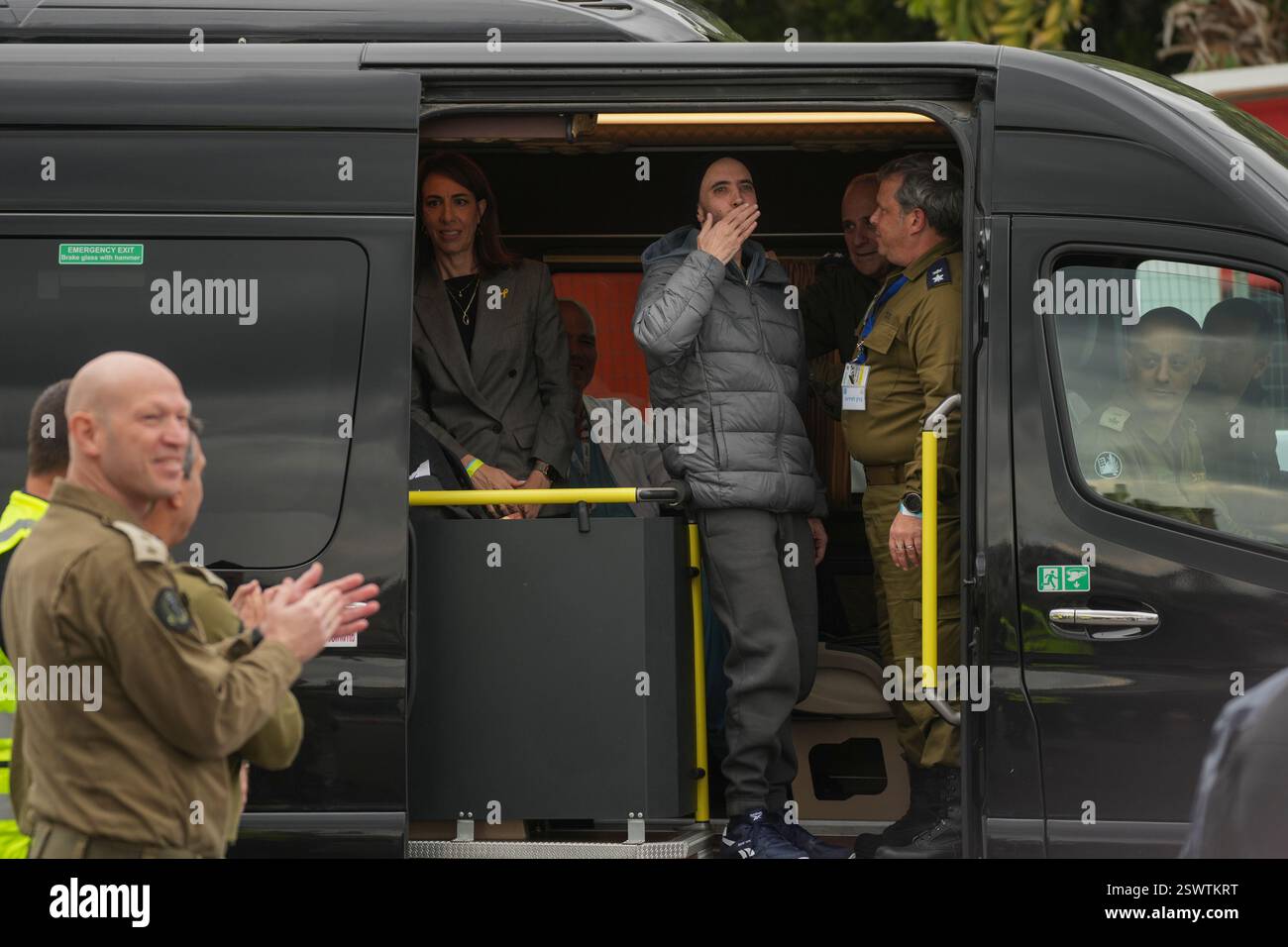 Freed Israeli hostage Tal Shoham waves from a van as he arrives at ...