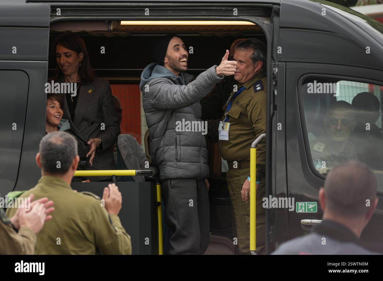 Freed Israeli hostage Tal Shoham waves from a van as he arrives at ...