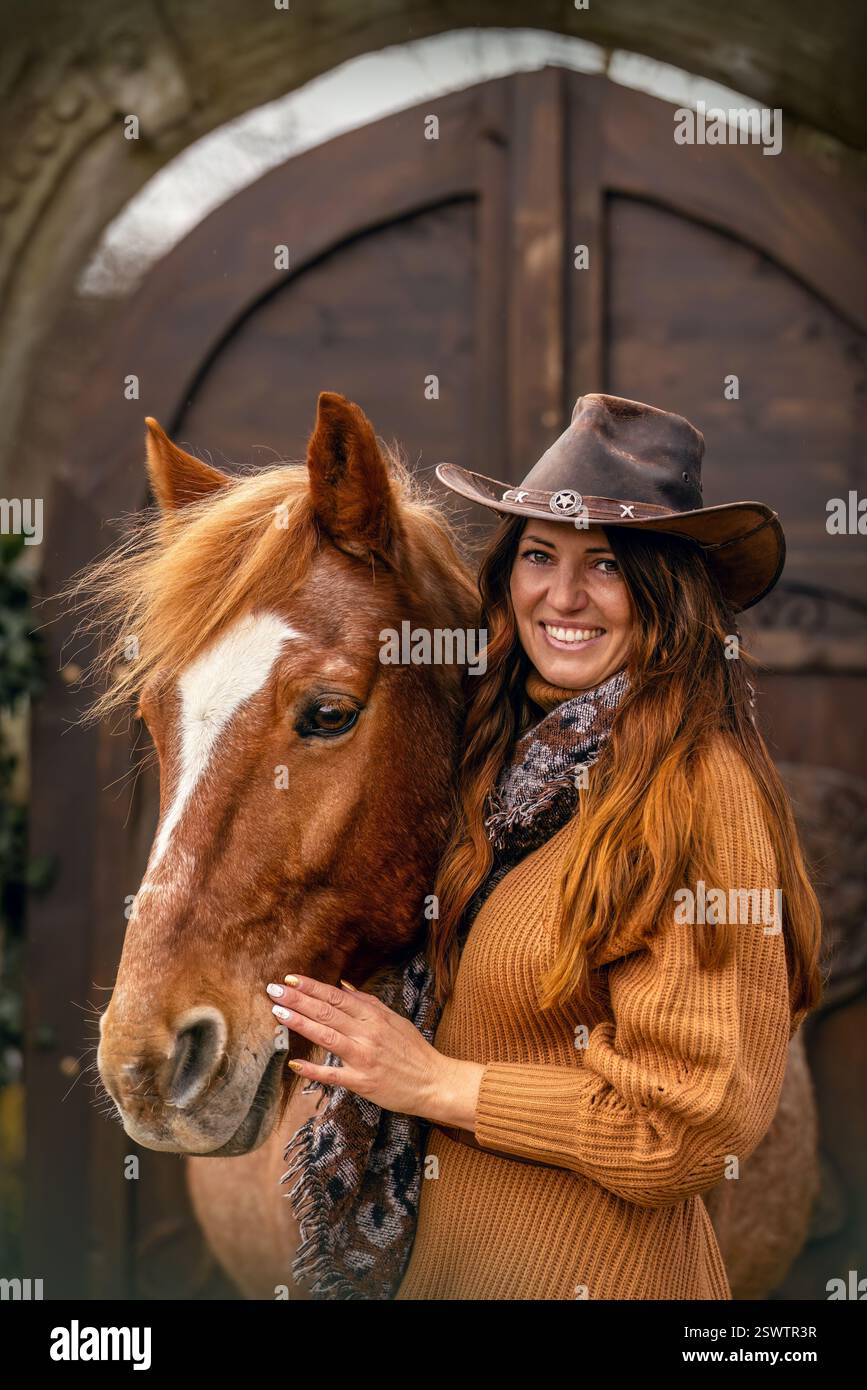 A beautiful adult woman and her brown horse cuddle and interact ...