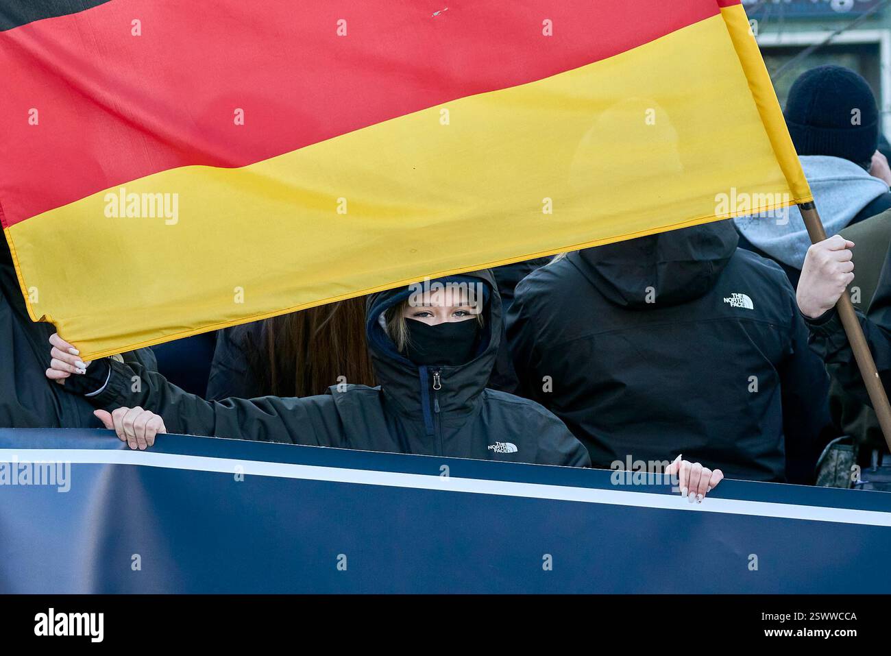 Berlin, Germany. 22nd Feb, 2025. A woman stands under the German flag ...