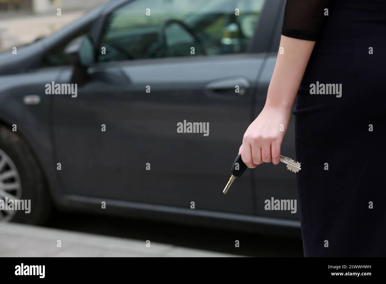 female hand holding car keys. Back view. female driver standing in ...
