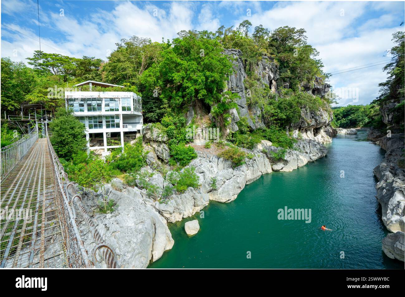 Turquoise river winding through towering limestone cliffs and lush ...