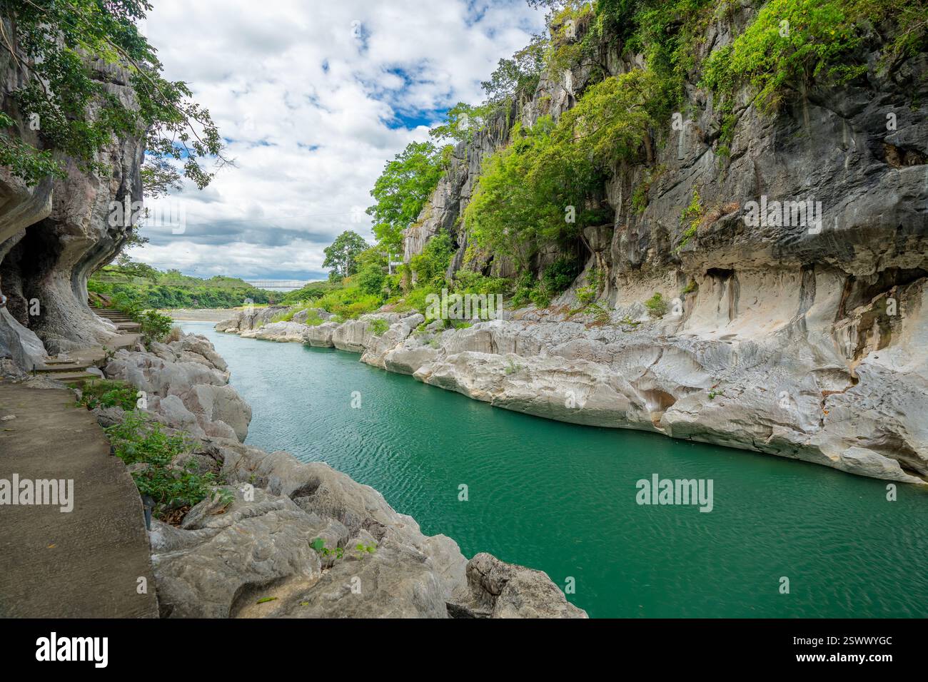 Turquoise river winding through towering limestone cliffs and lush ...