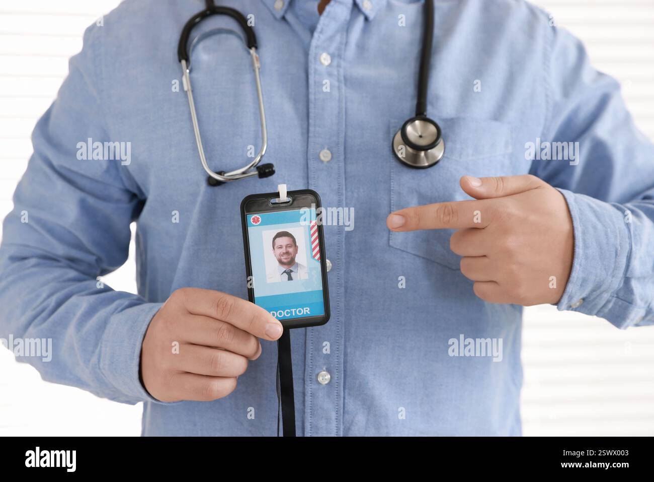 Doctor pointing at his badge in hospital, closeup Stock Photo - Alamy