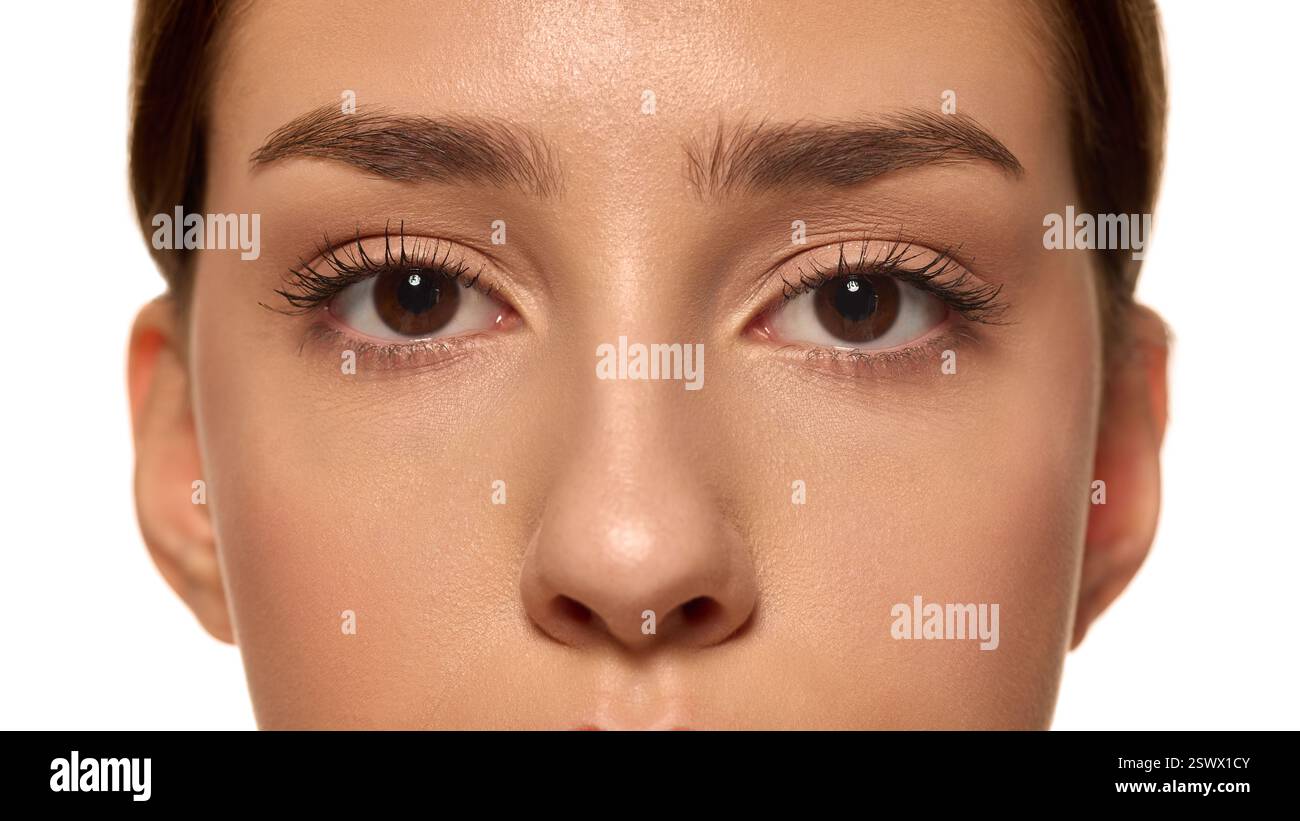 Close-up of young woman's eyes with well-defined, well-groomed eyebrows and long lashes against ...