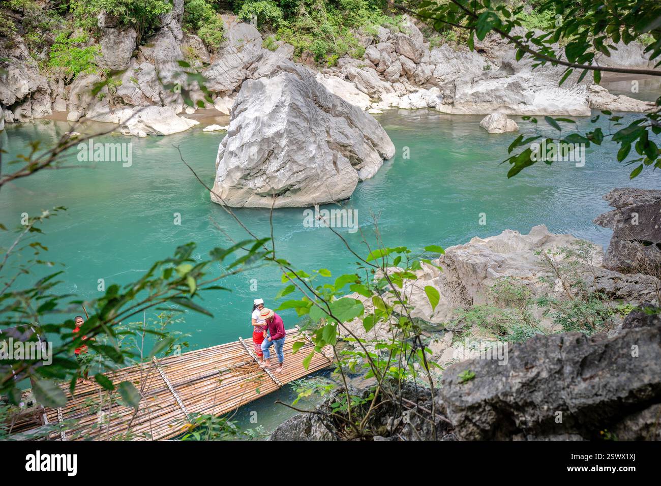 Turquoise river winding through towering limestone cliffs and lush ...