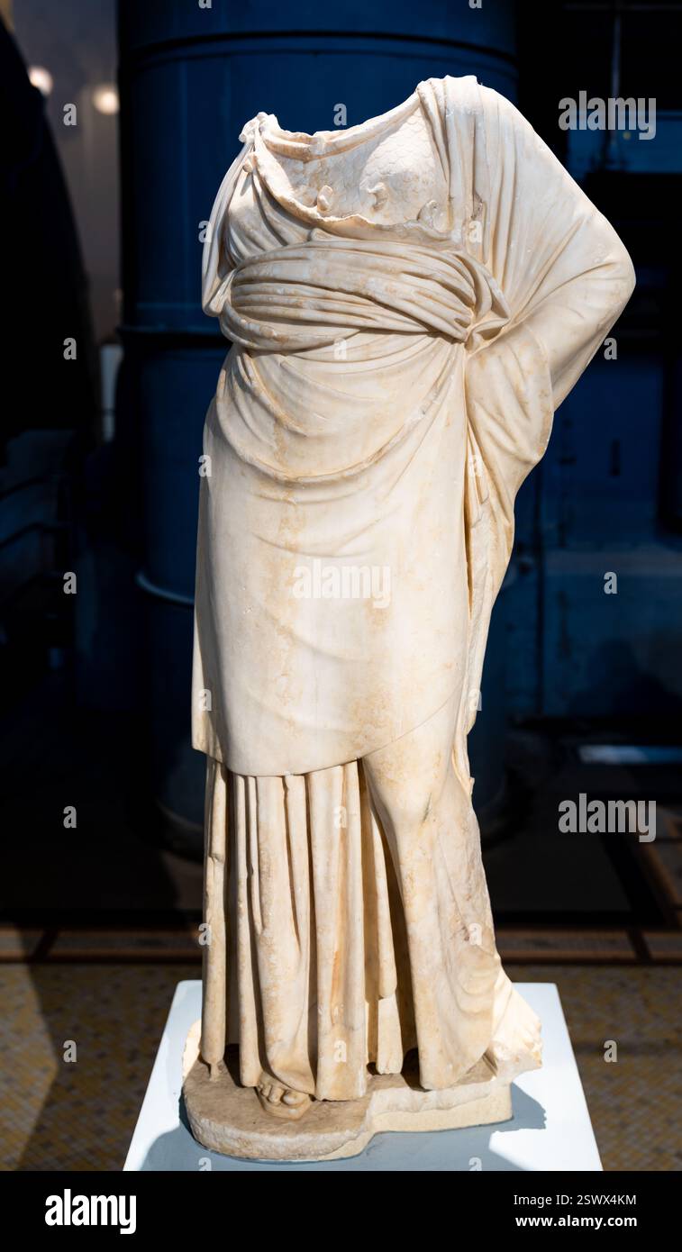 Ancient marble statue in ruins representing a headless body wearing a ...