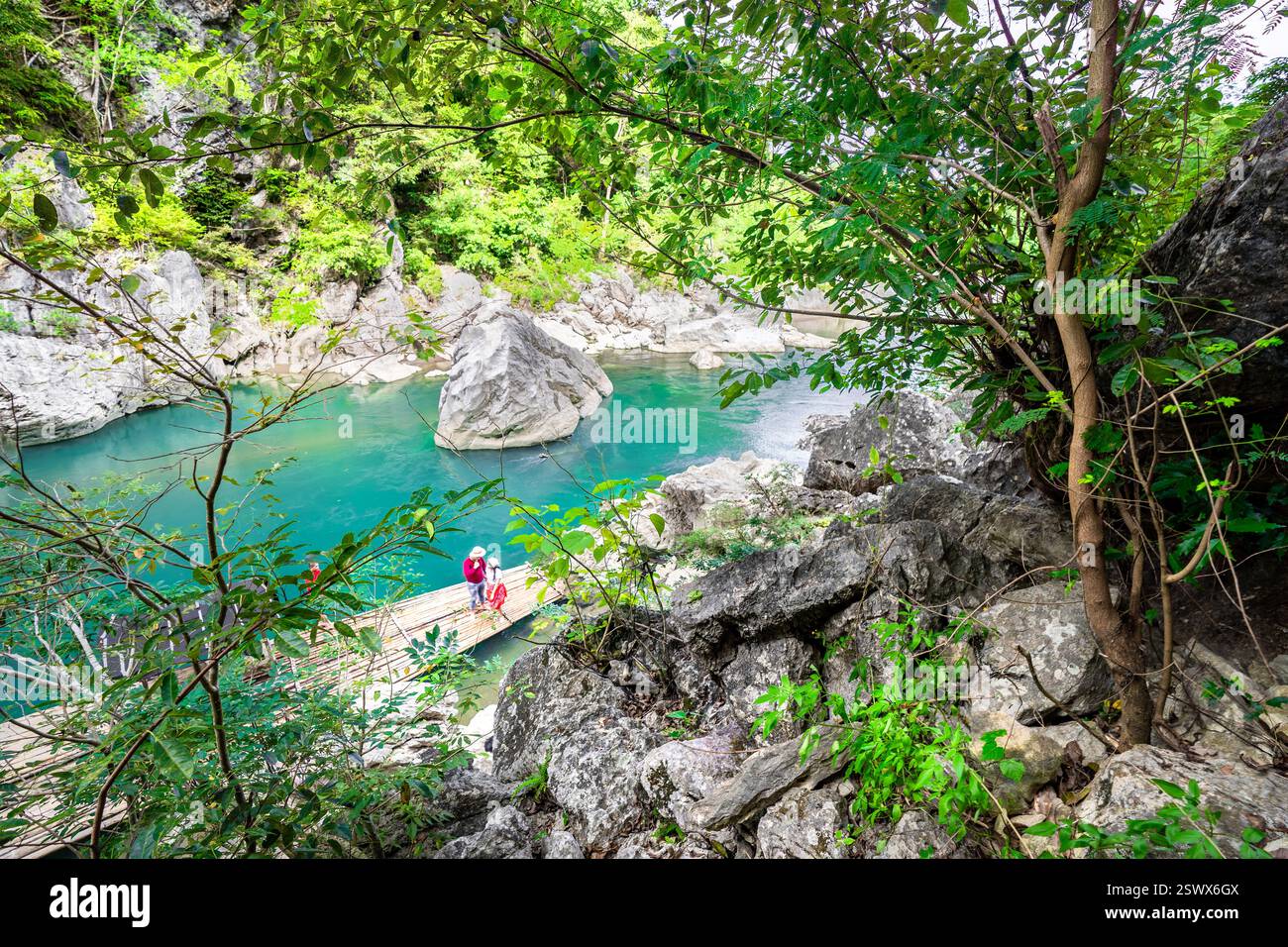 Turquoise river winding through towering limestone cliffs and lush ...
