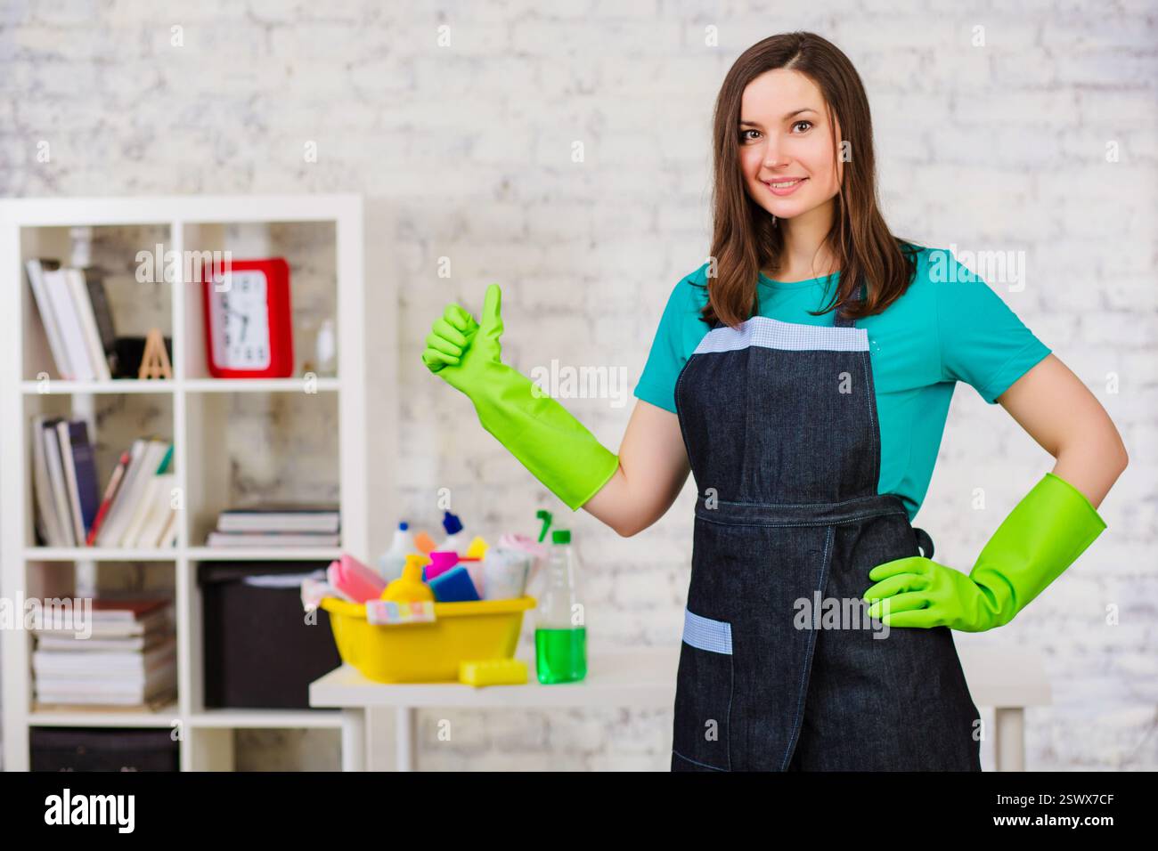 Portrait positive woman janitor showing thumbs up,standing in a modern ...