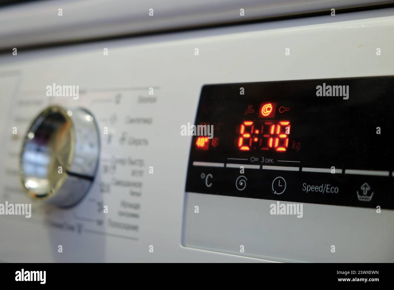 Close-up of a washing machine control panel with a digital display and ...