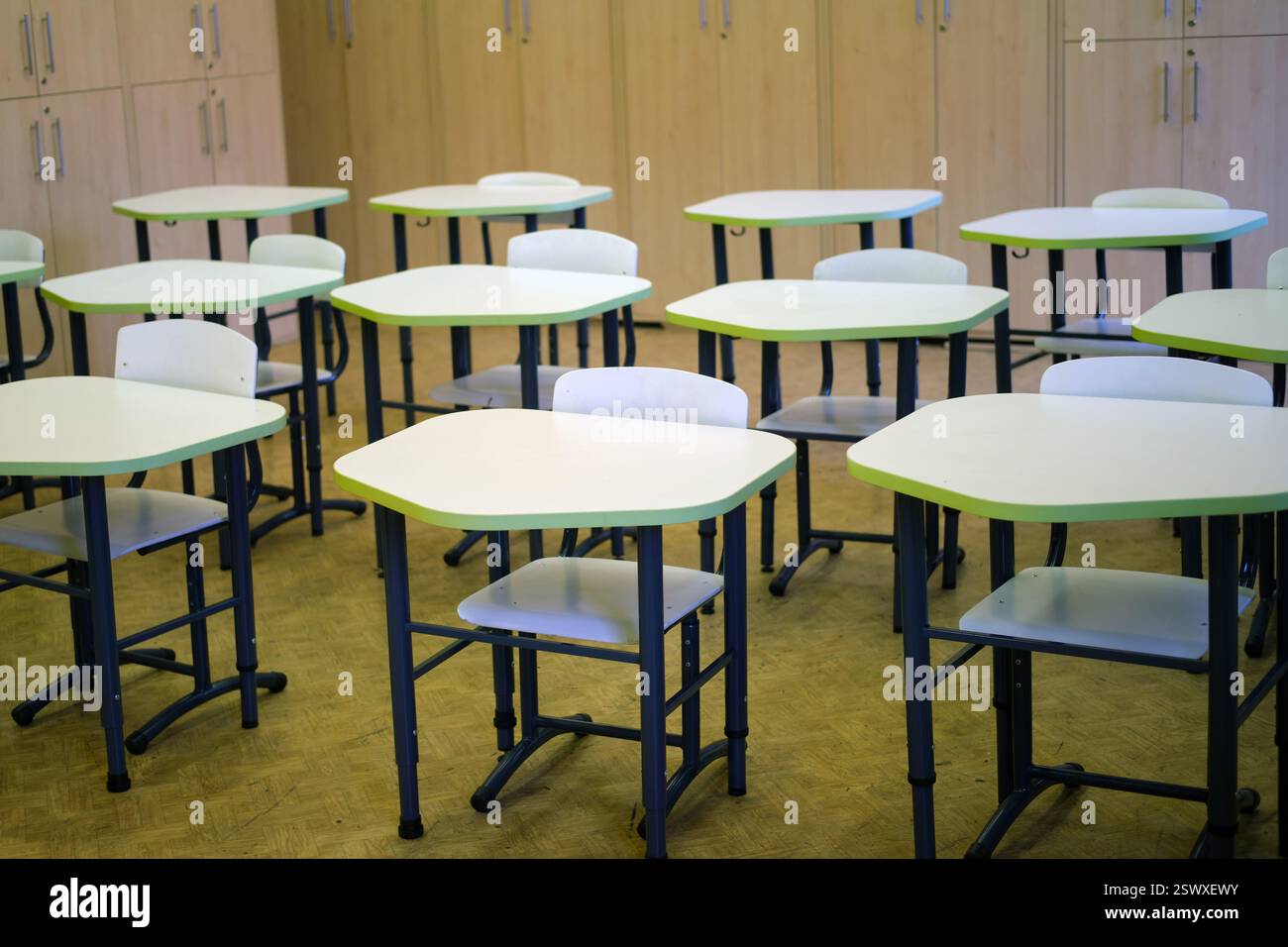 Empty classroom with modern student desks and chairs arranged in rows ...
