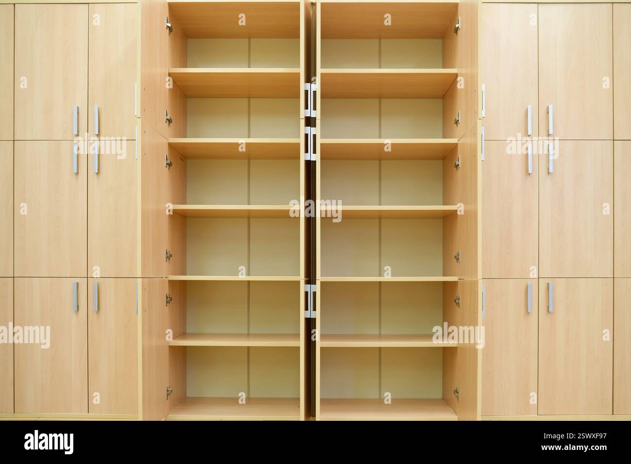 Empty wooden bookshelf with open doors and multiple shelves ...