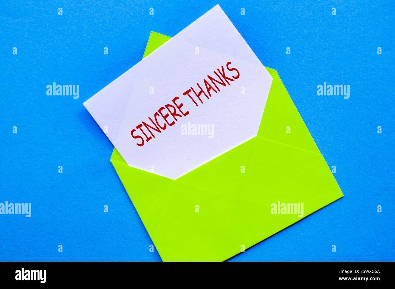 Green envelope on a blue cover with a white card partially pulled out ...