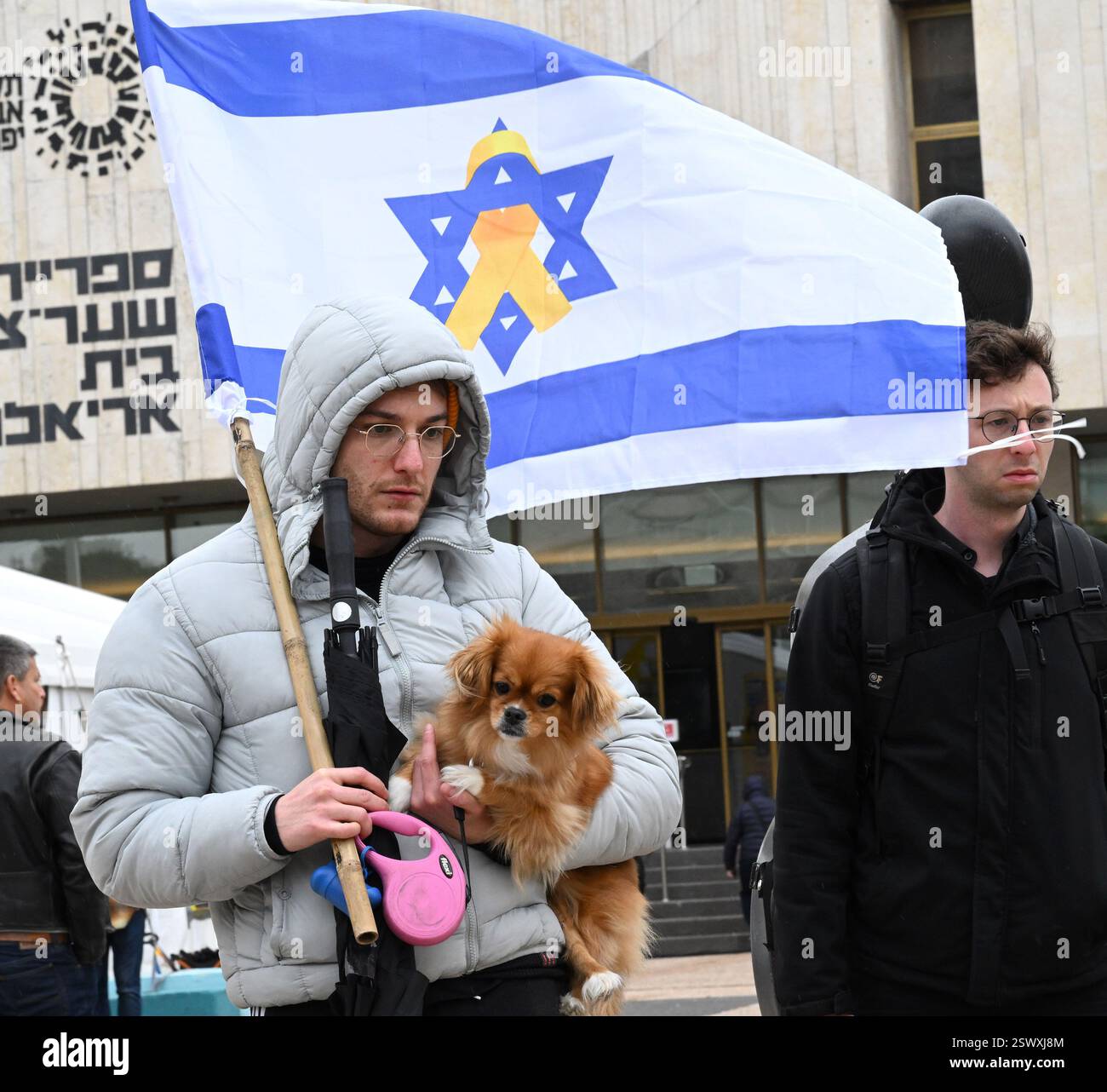 A man holds the national flag and a dog in Hostage Square in Tel Aviv ...