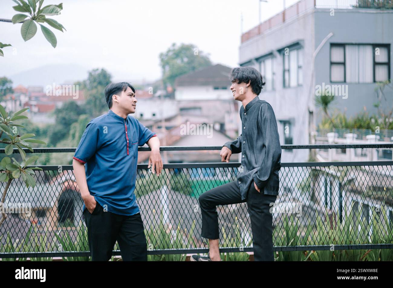 Two young men are captured in a relaxed conversation on an overcast day ...