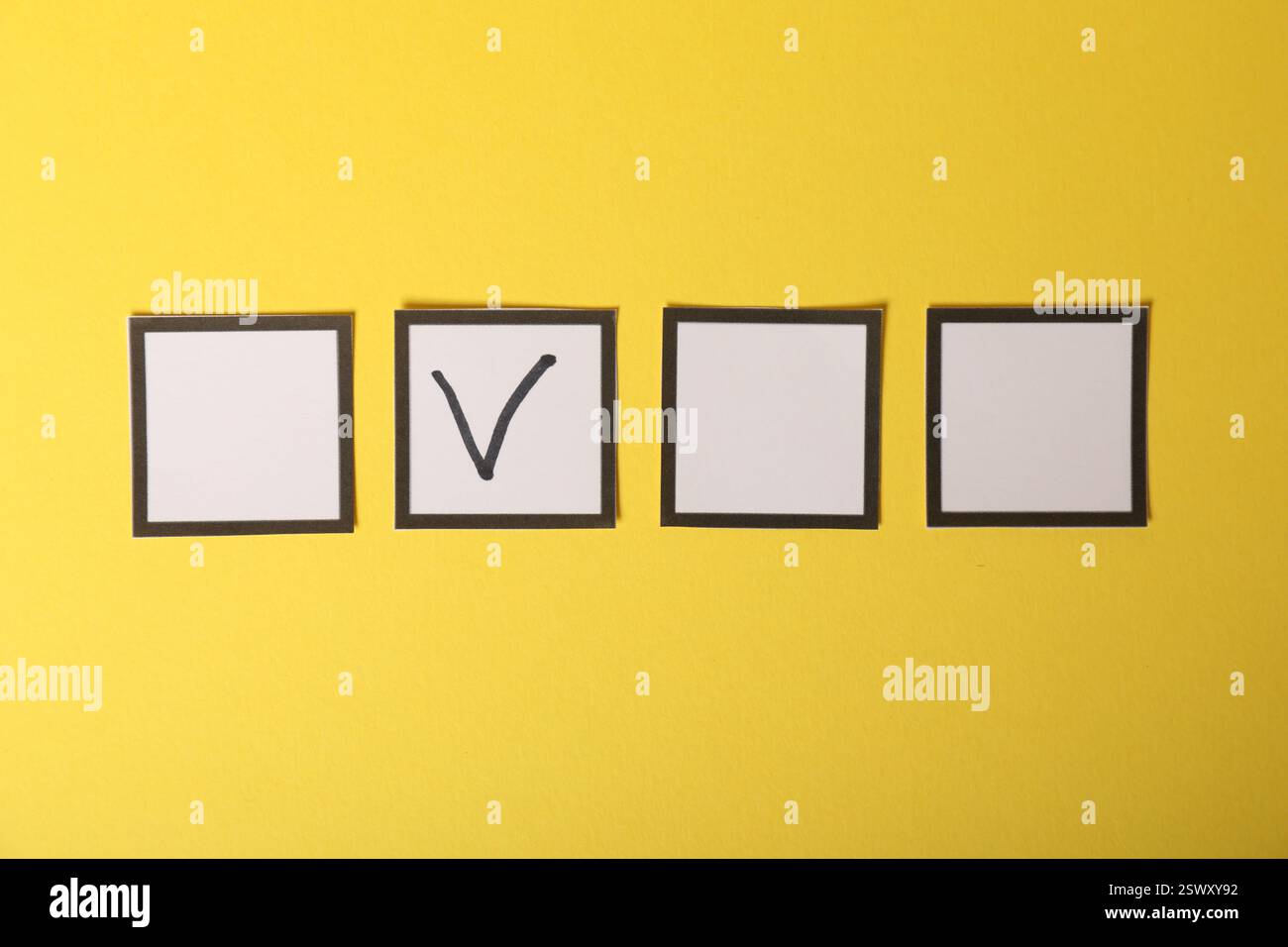 One checkbox with tick mark among others on yellow background, flat lay ...