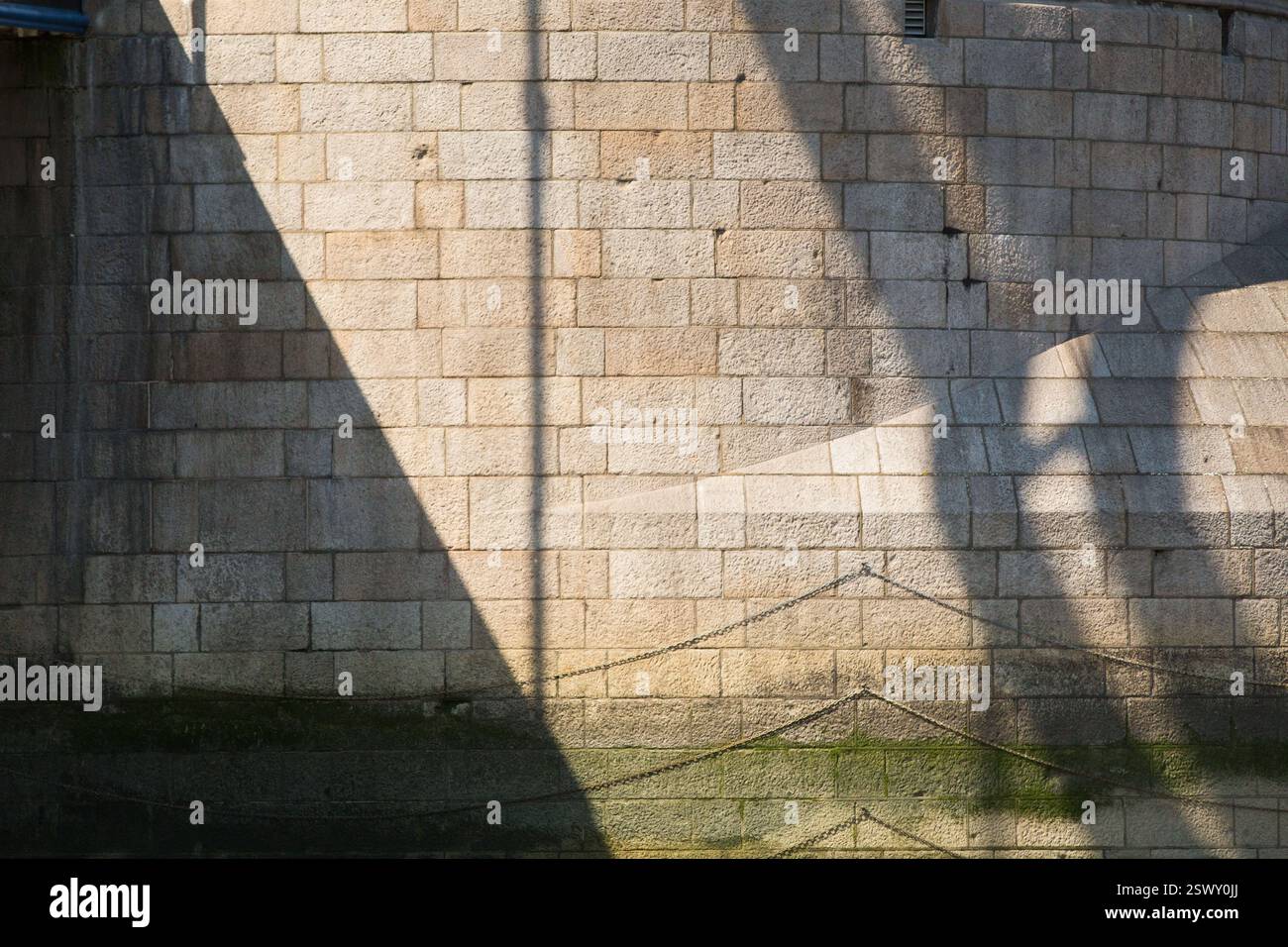 Stone wall of the Tower Bridge, London, England, showing shadows cast ...