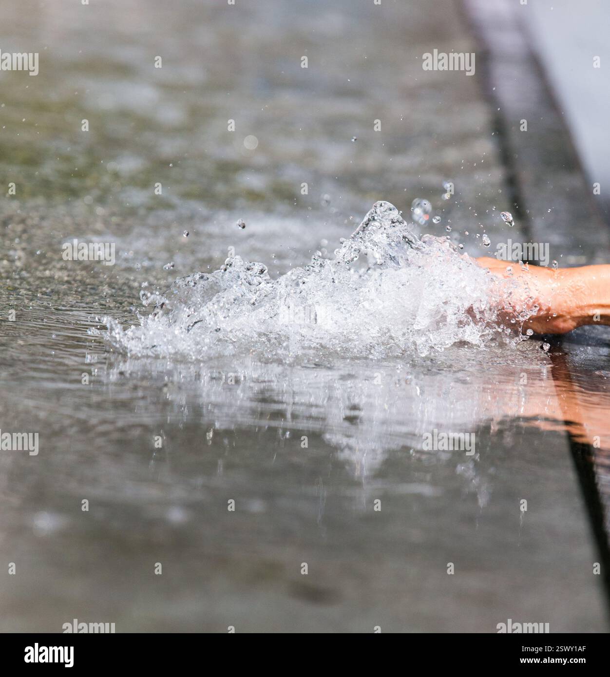 More London fountains Person disturbing water Stock Photo - Alamy