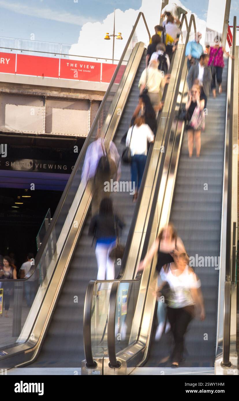 Commuters use escalators at the London Bridge station, near the Shard ...