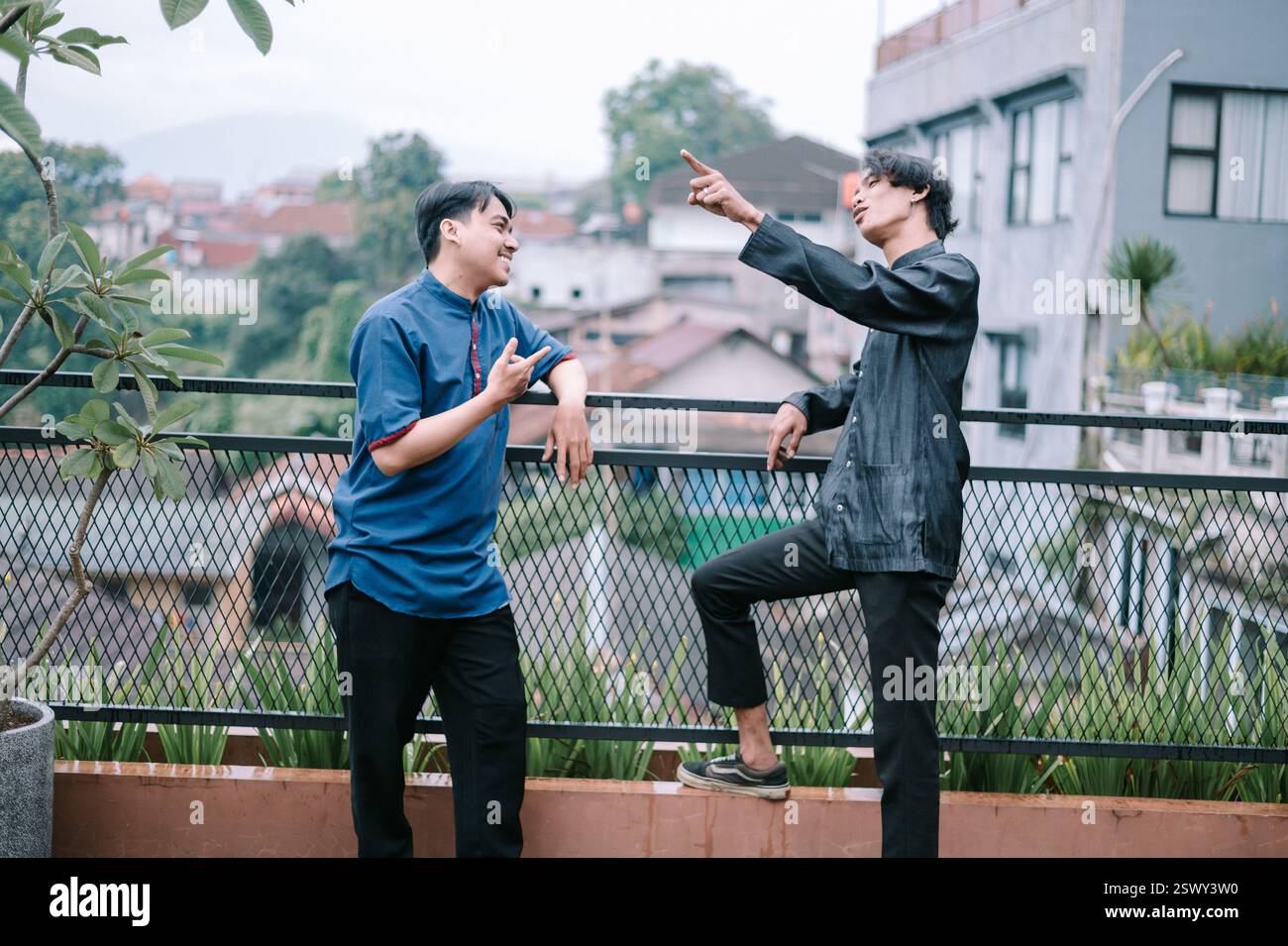 Two young men engaging in lively conversation on a rooftop with a ...