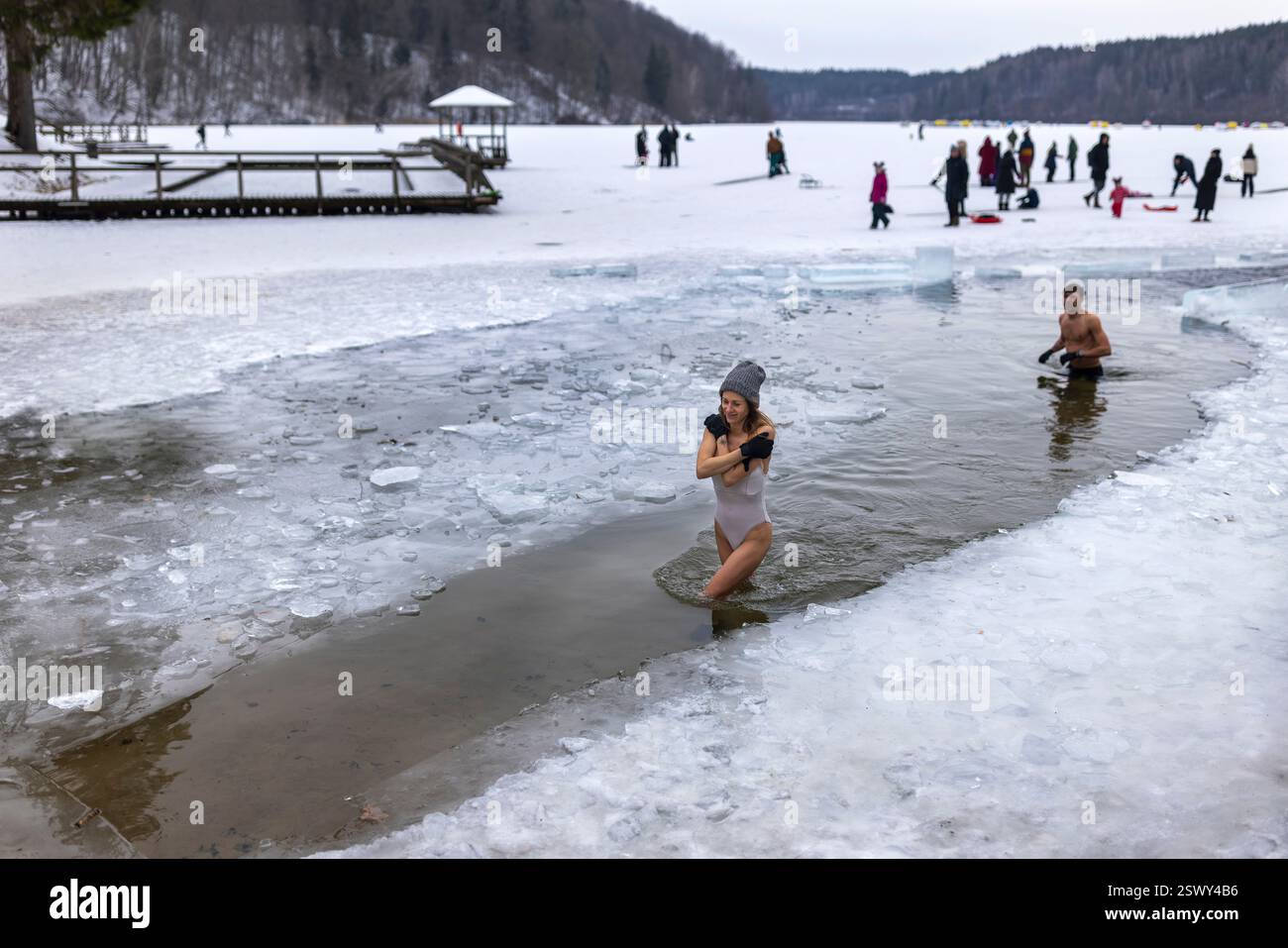 People bathe in an ice hole in a lake near Vilnius, in the icy water in ...