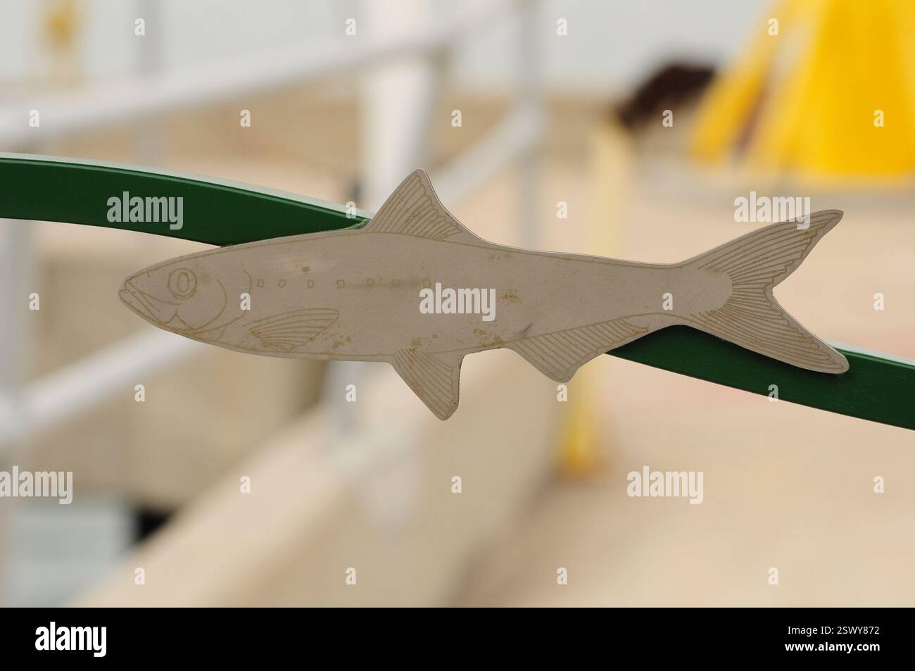 Fish sculpture adorns vibrant railing with urban backdrop Stock Photo ...