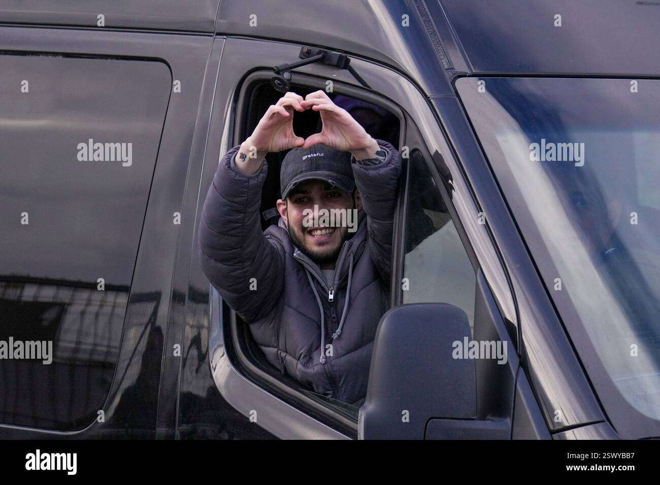 Freed Israeli hostage Eliya Cohen gestures from a van as he arrives at ...