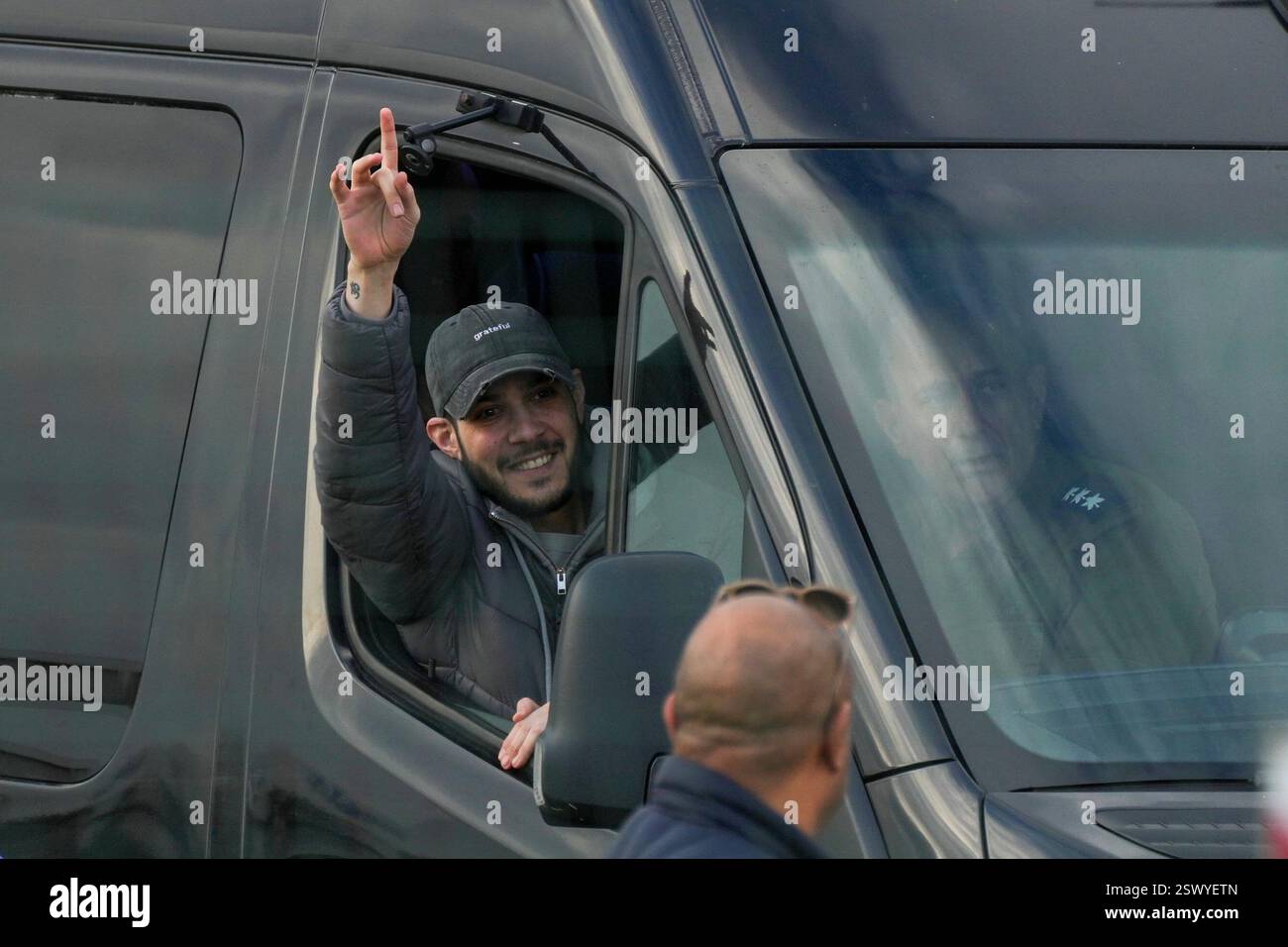 Freed Israeli hostage Eliya Cohen gestures from a van as he arrives at ...