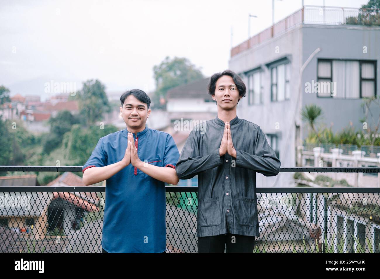Two young asian men expressing respect and cultural greeting with a ...