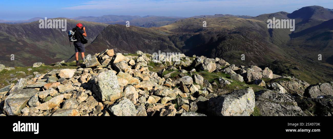 Walker at the summit cairn of High Crag fell above Buttermere, Lake ...