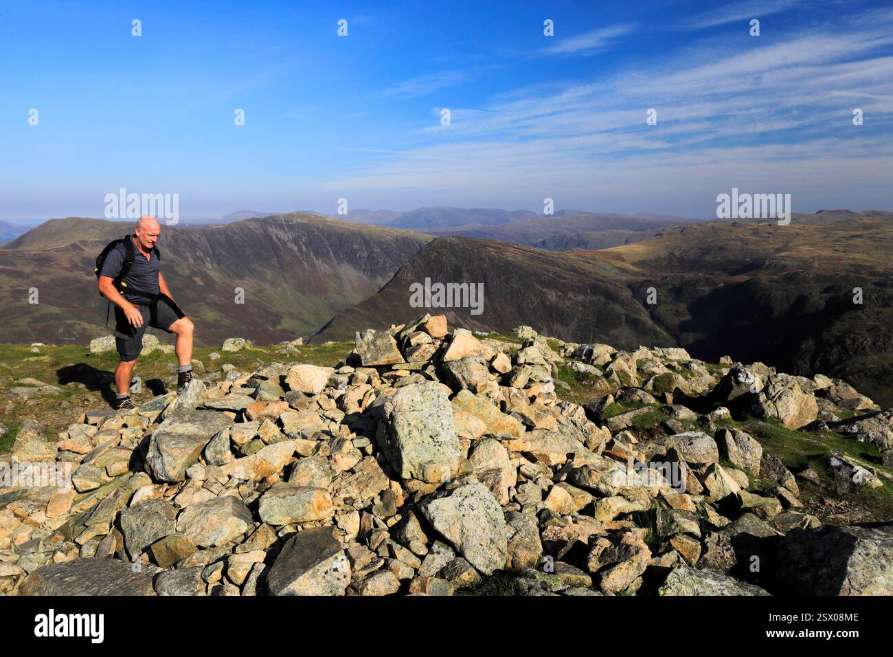 Walker at the summit cairn of High Crag fell above Buttermere, Lake ...