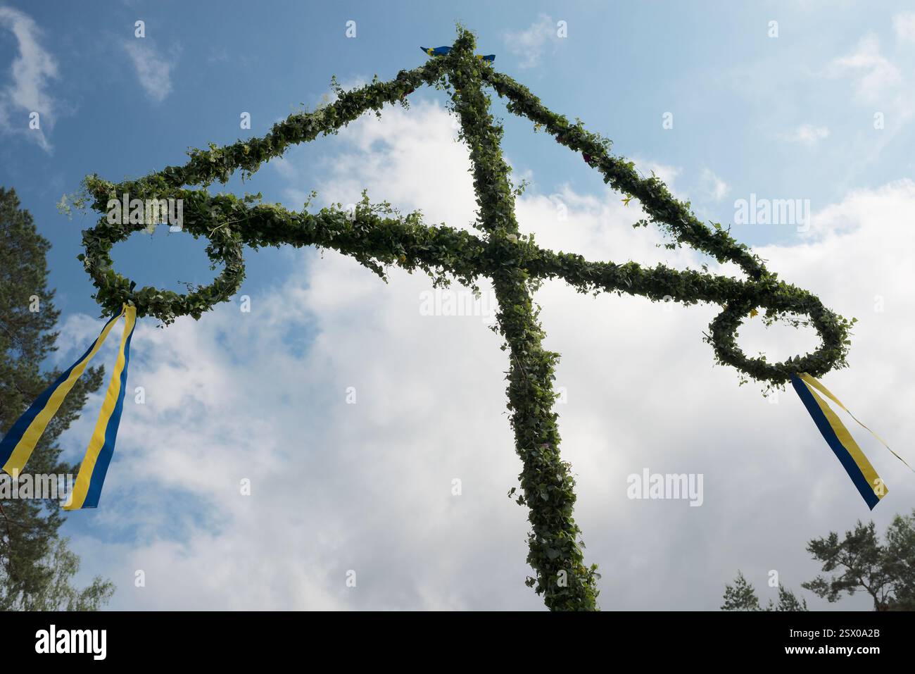 A traditional swedish midsummer pole with a blue and yellow ribbons ...