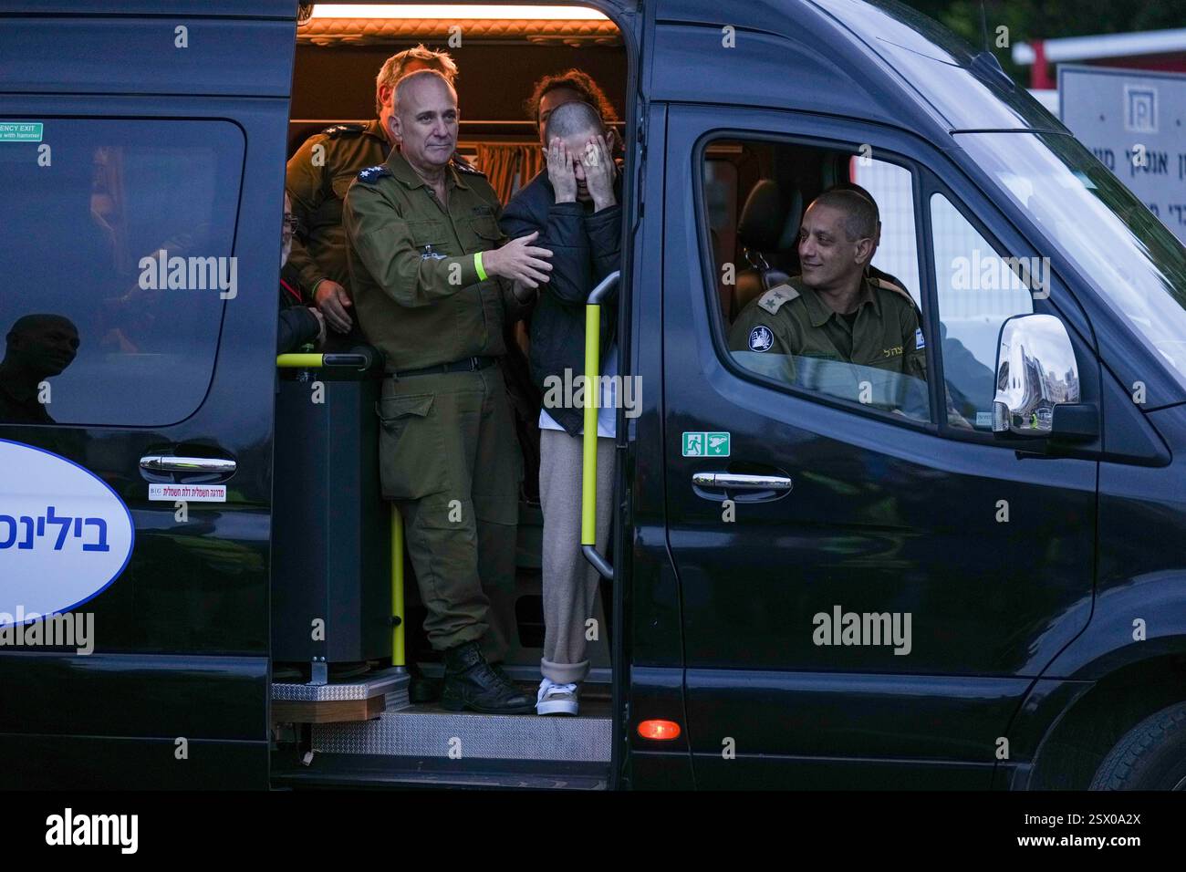 Freed Israeli hostage Omer Wenkert, gestures from a van as he arrives ...