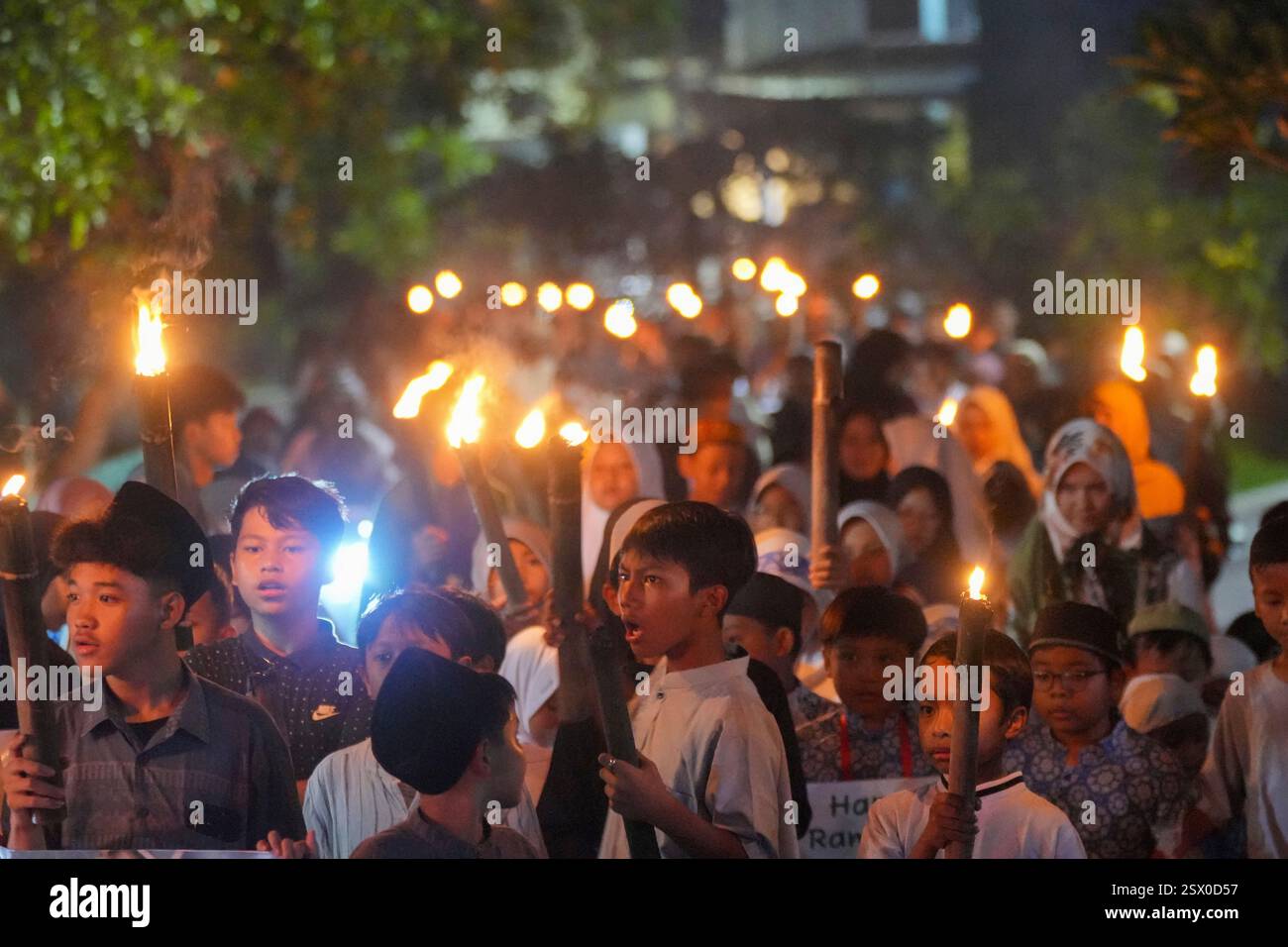 Muslim youths hold torches during a parade welcoming the holy fasting ...