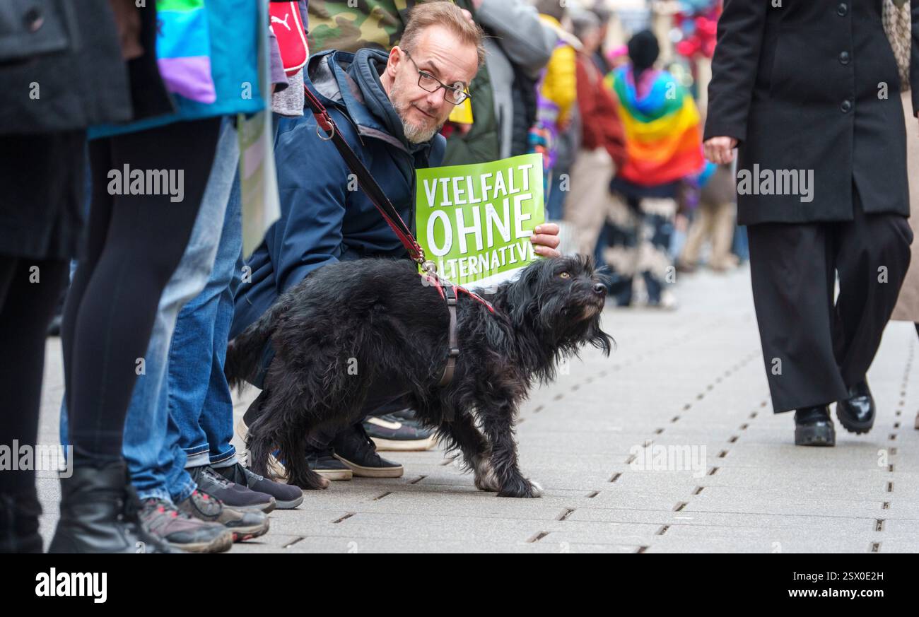 22 February 2025, Hesse, Wiesbaden: A man holds a poster with the words ...
