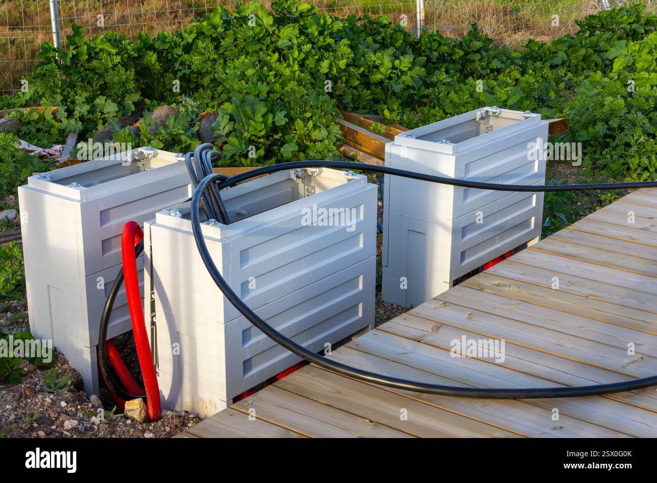 Thick black and red cables connecting electrical junction boxes placed ...