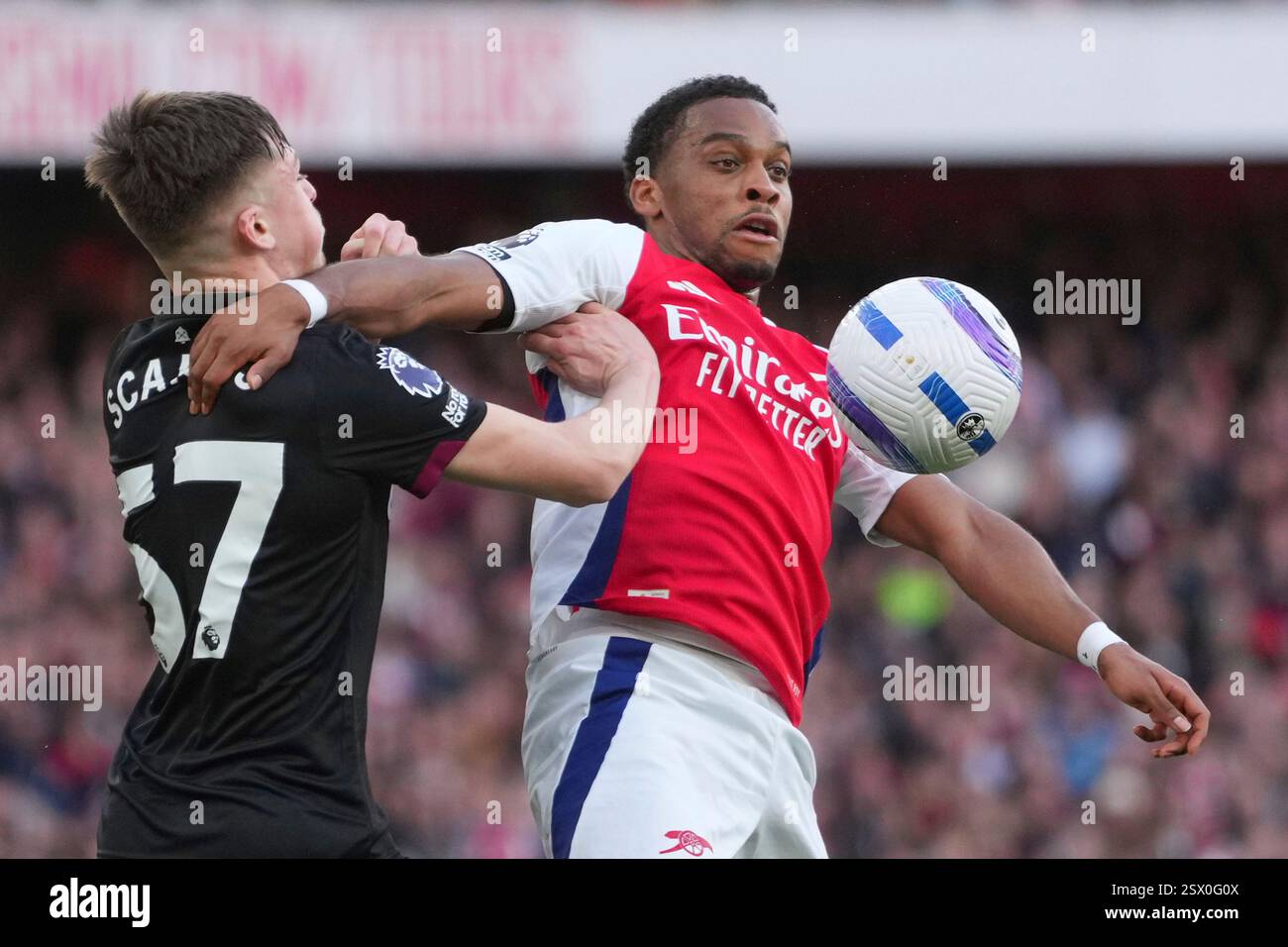West Ham's Oliver Scarles, left, challenges for the ball with Arsenal's ...