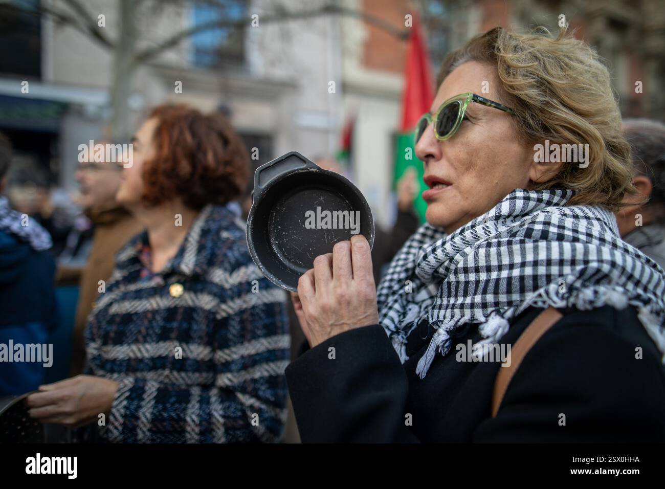 A demonstrator bangs and makes noise with a pot during a demonstration ...