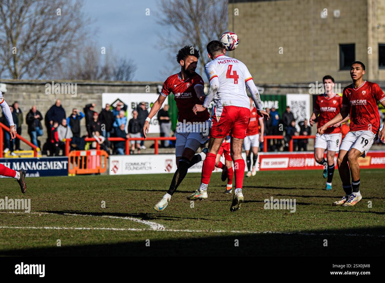 Oisin McEntee of Walsall FC heads away a shot under pressure from ...
