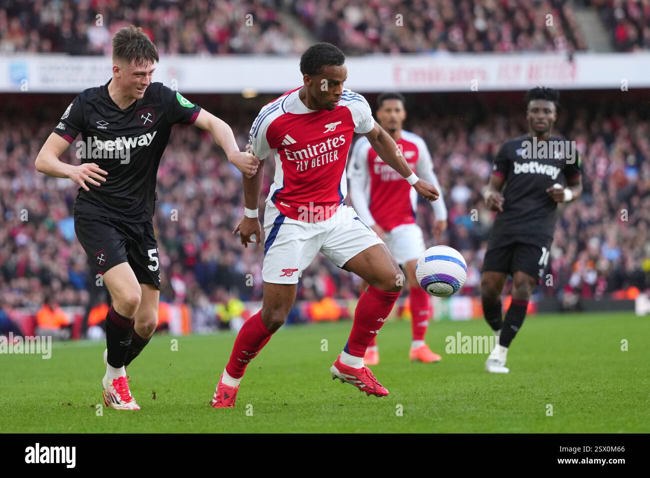 West Ham's Oliver Scarles, left, challenges for the ball with Arsenal's ...