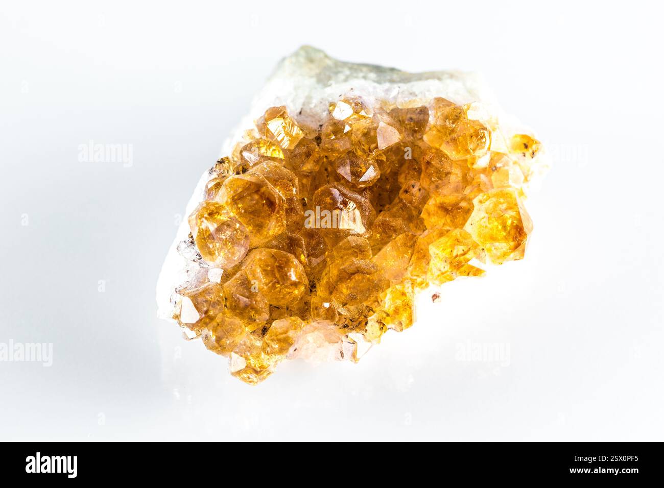 Yellow rock with brown spots. It is a piece of amber. It is on a white ...