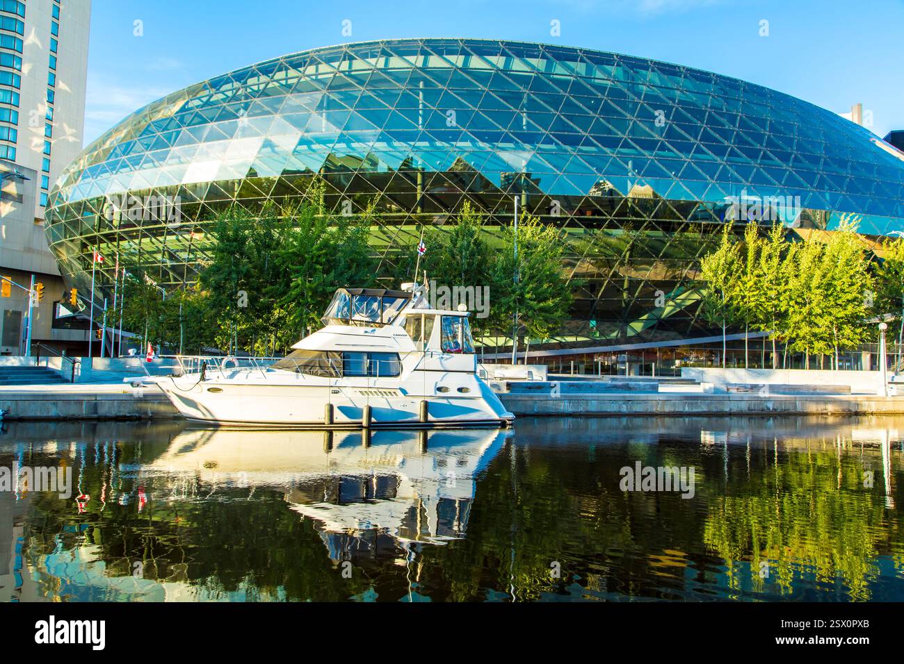 Boat is floating in a body of water next to a building. The boat is ...