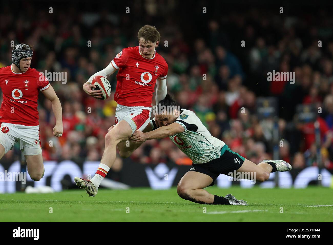 Cardiff, UK. 22nd Feb, 2025. Ellis Mee of Wales makes a break past James Lowe of Ireland ...