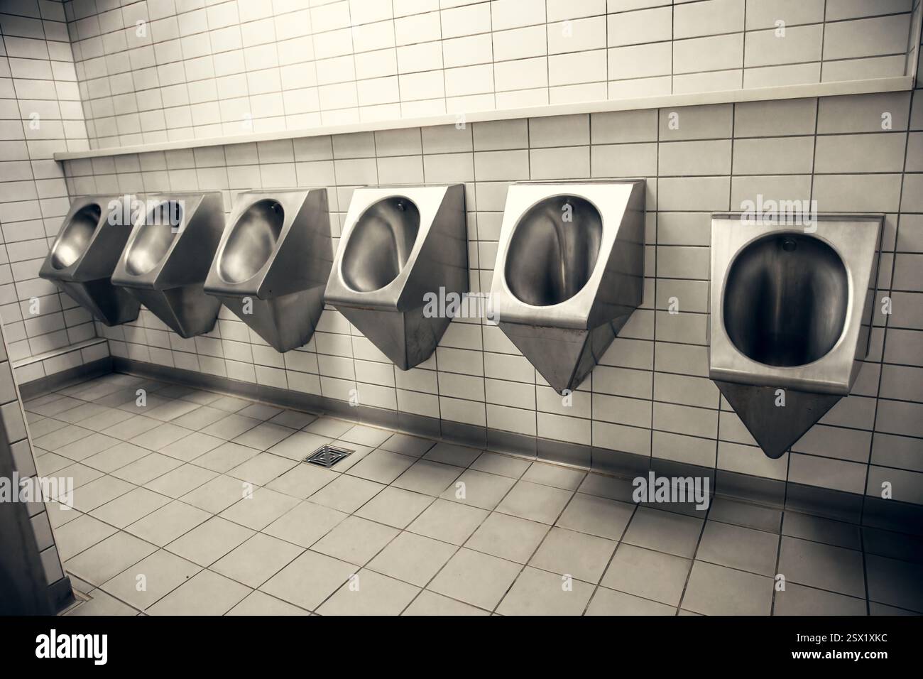 Row of stainless steel urinals in a public restroom. Modern and ...
